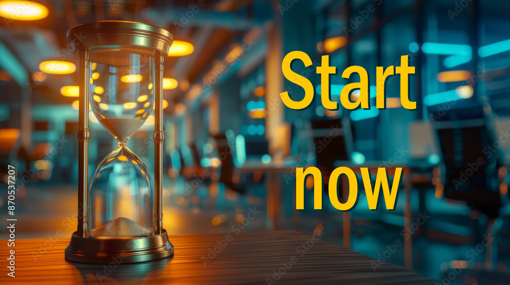 Start now text next to hourglass on office background. Business concept ...