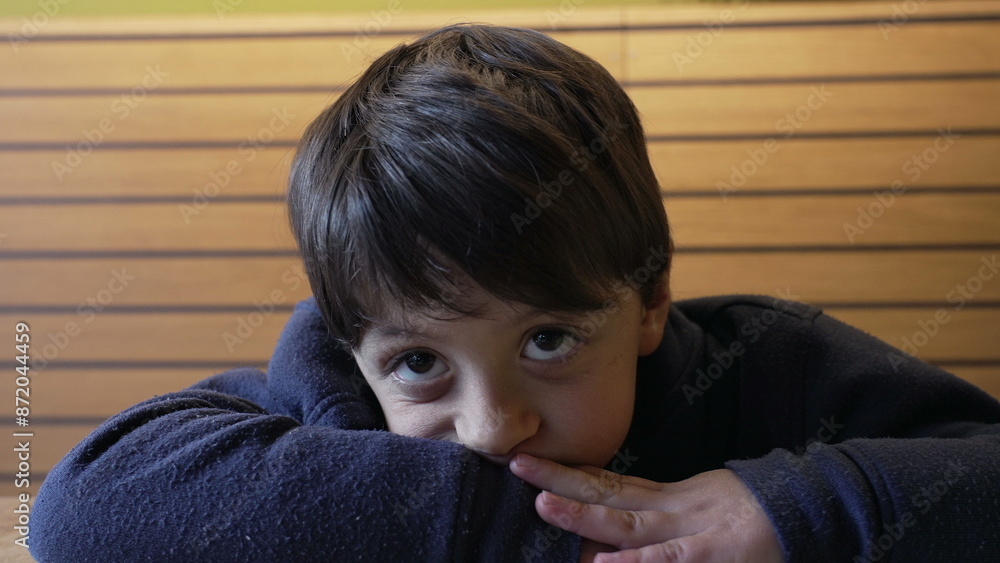 Young Boy Being Goofy and Playful, Resting His Head on a Table with a ...