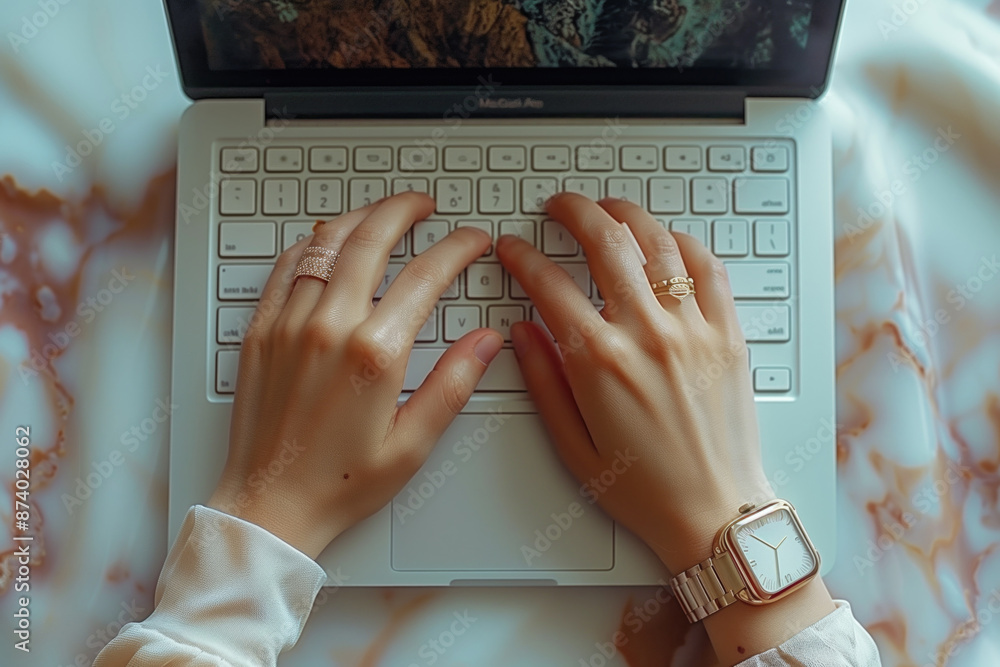 Woman typing on a laptop keyboard wearing jewelry and a smartwatch on a ...