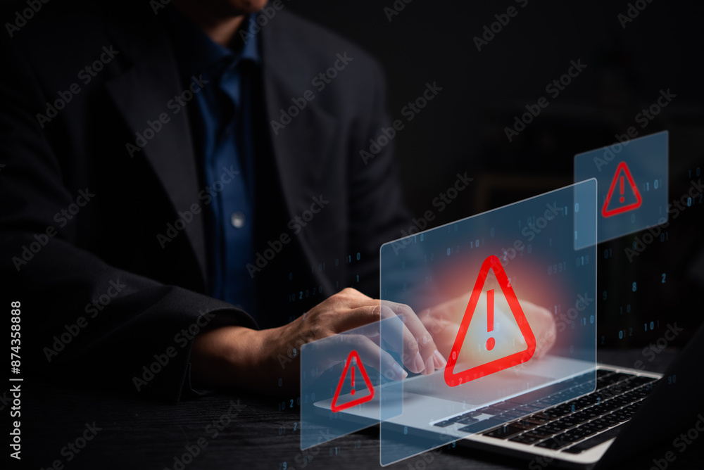 Man typing on laptop with floating red warning icons. Represents ...