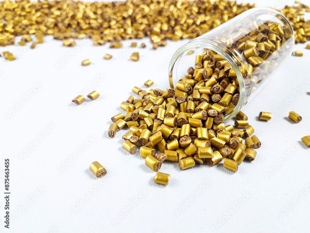 Gold color masterbatch granules with glass tube on white background ...