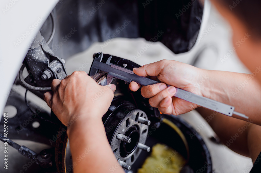 Use a vernier to measure the thickness of the brake disc.Mechanic uses ...