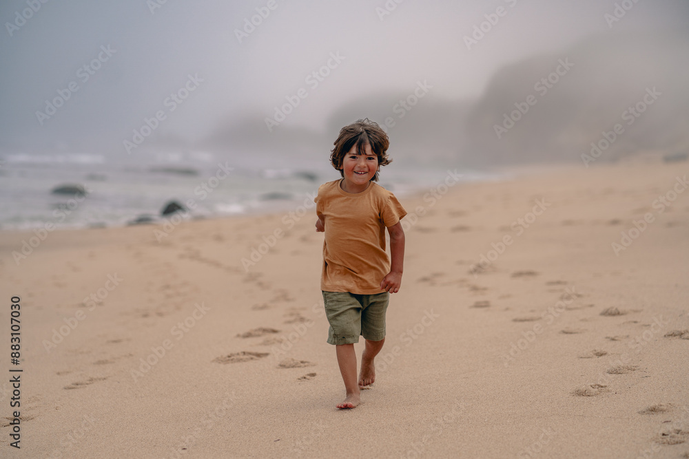 cute happy child running fast on the beach with the background of the ...