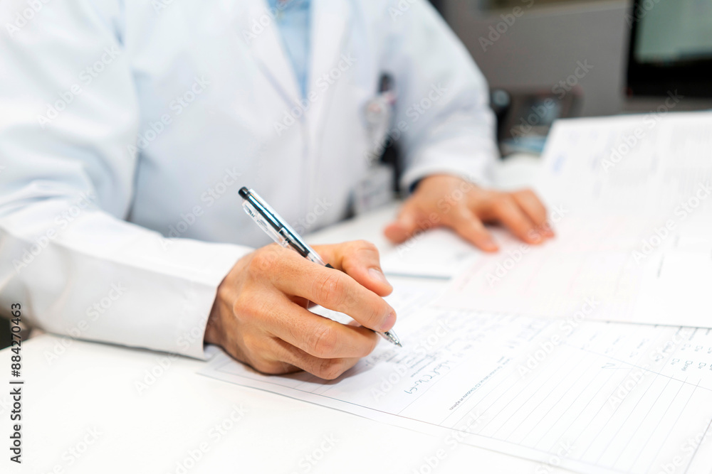 cardiologist looking at electrocardiograph ekg paper filling patient ...