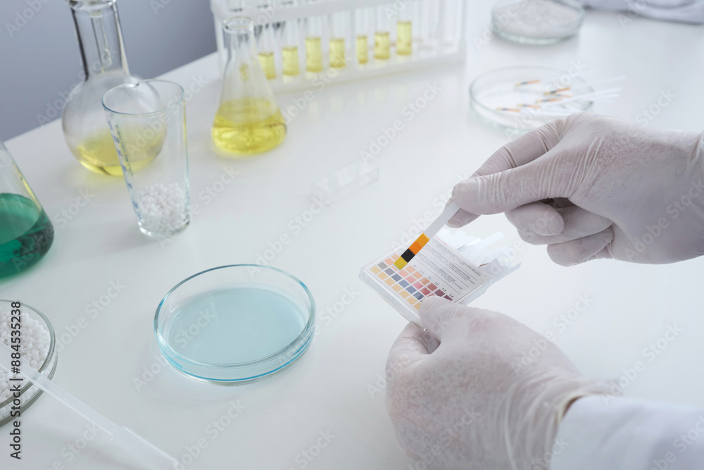 A scientist in a chemical laboratory takes measurements of the acid ...