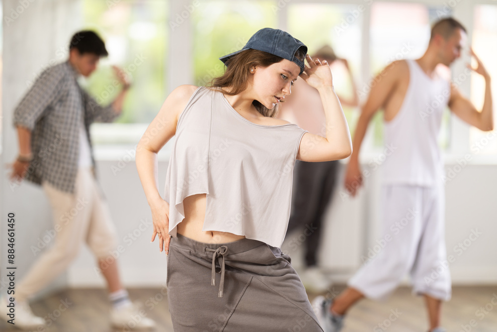 Girl during hip hop dance rehearsal, left general group of dancers ...