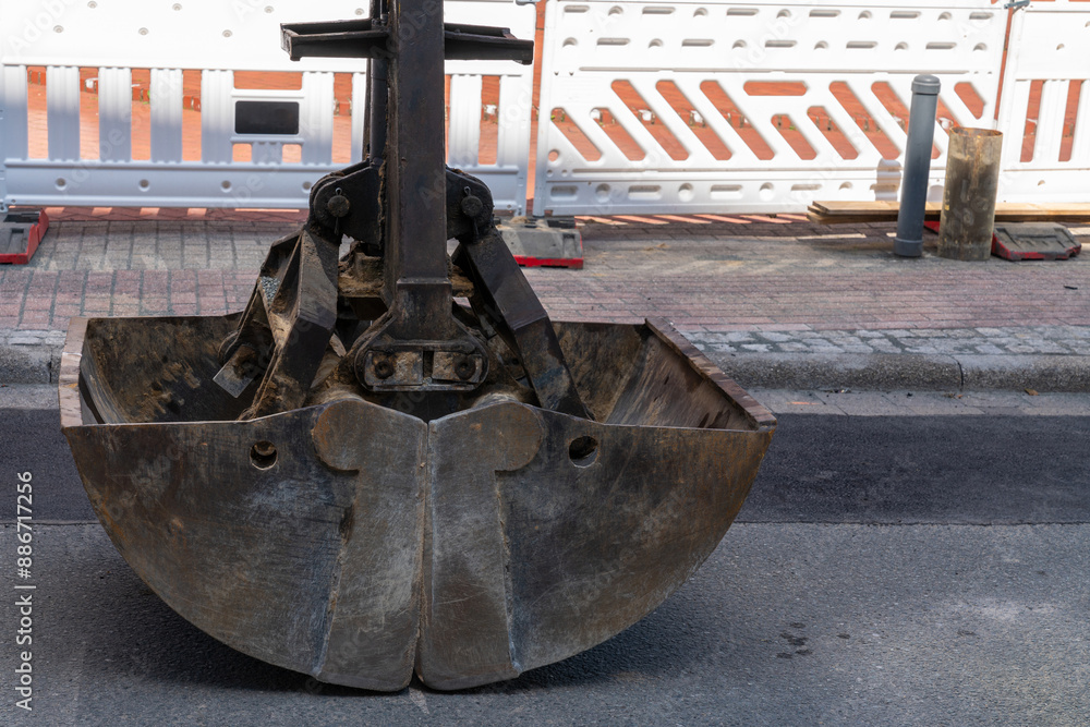 The image captures the clamshell bucket of an excavator positioned on a ...