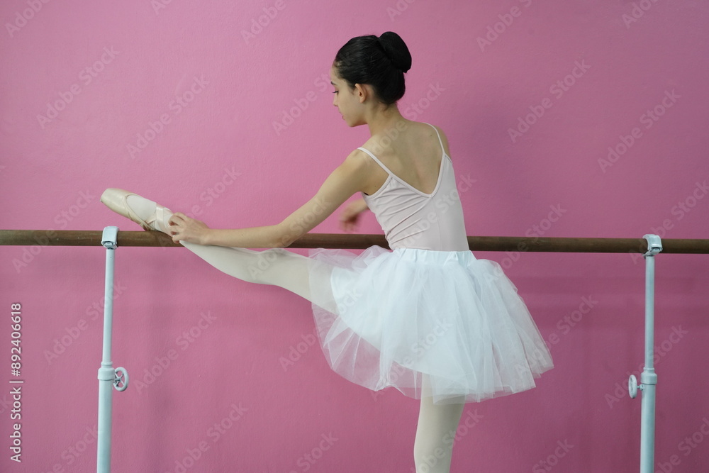 Young beautiful young woman in white ballet tutu practicing ballet ...