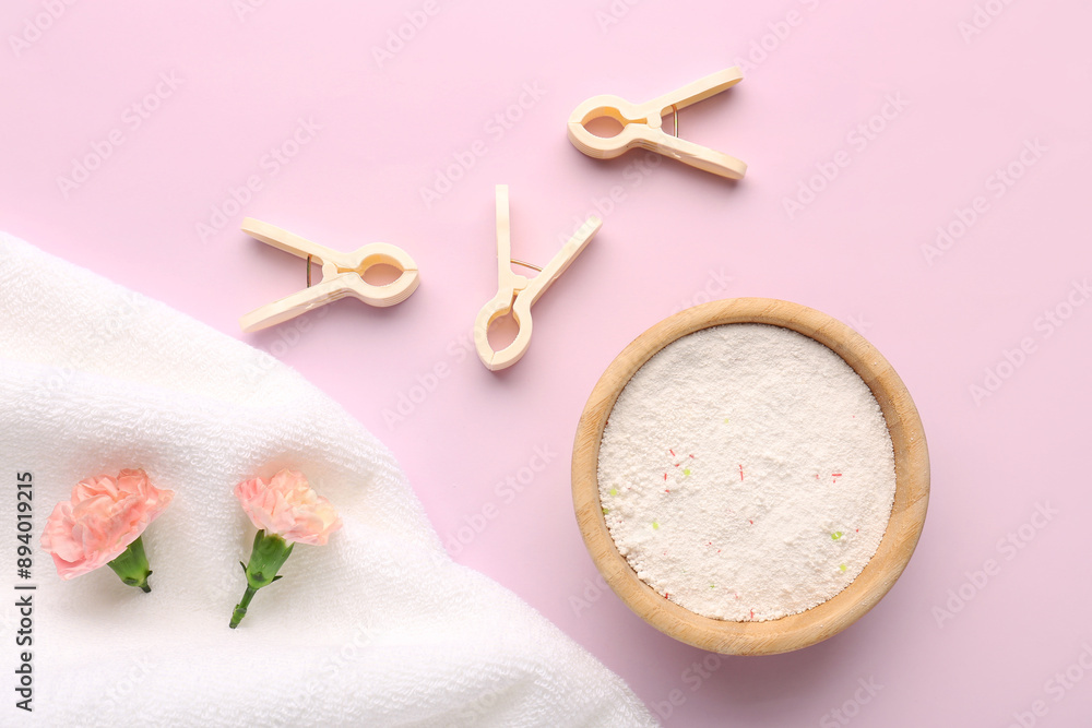 Laundry detergent, clothespins and carnation flowers on pink background ...