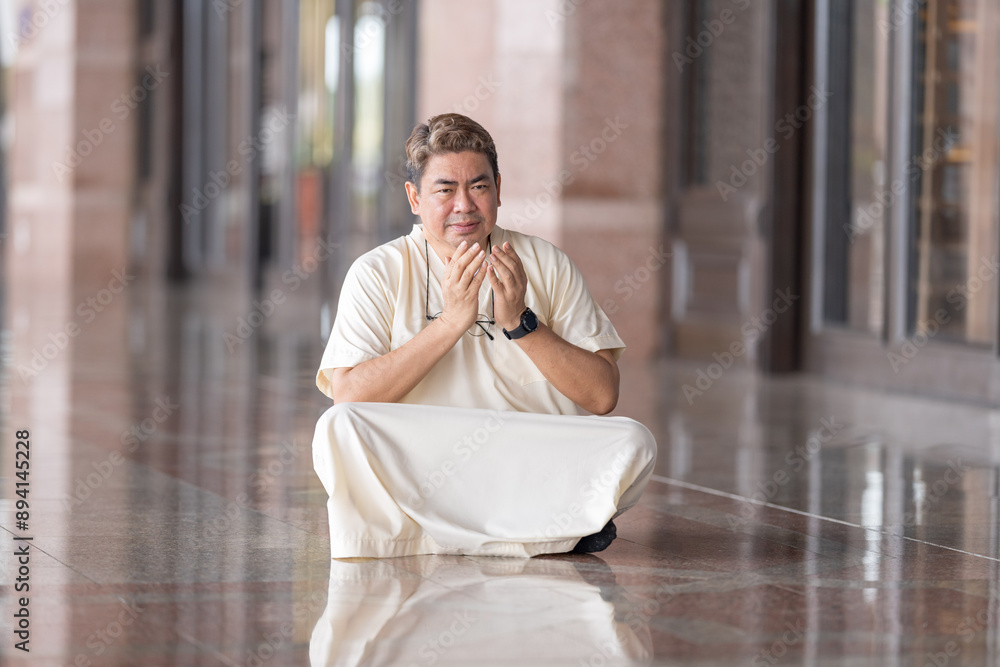 Fifty-something Muslim Malay person in religious attire, wearing a ...
