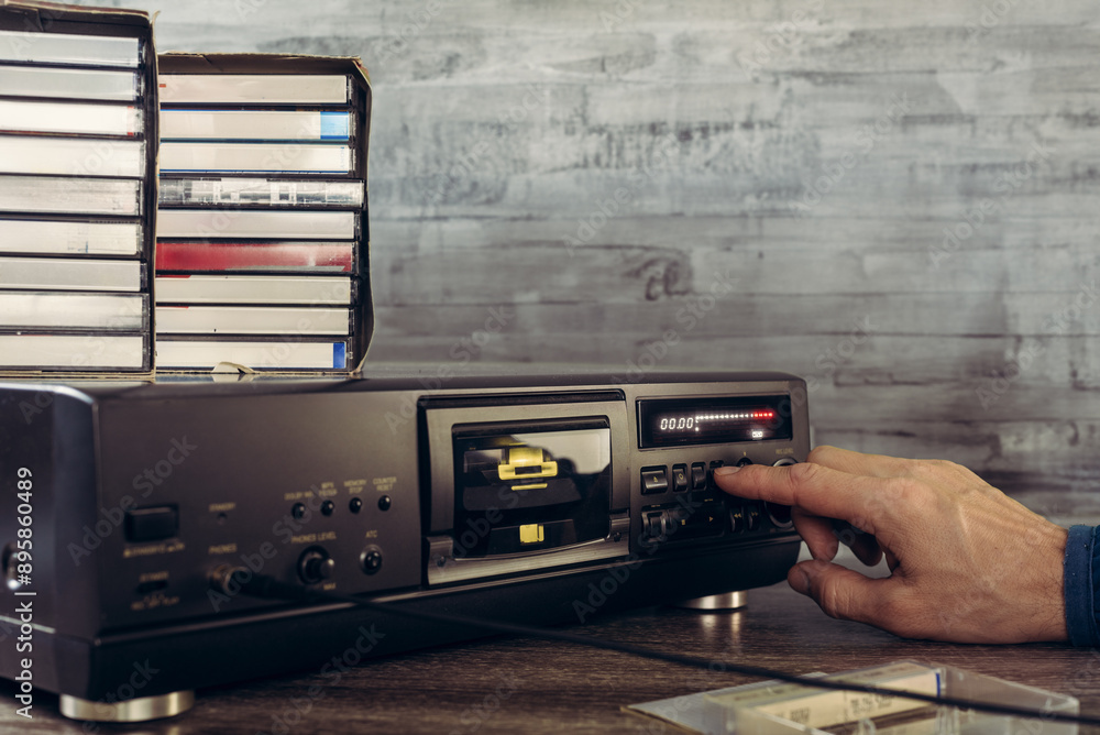 Man pressing play button on old tape recorder to play music from his ...