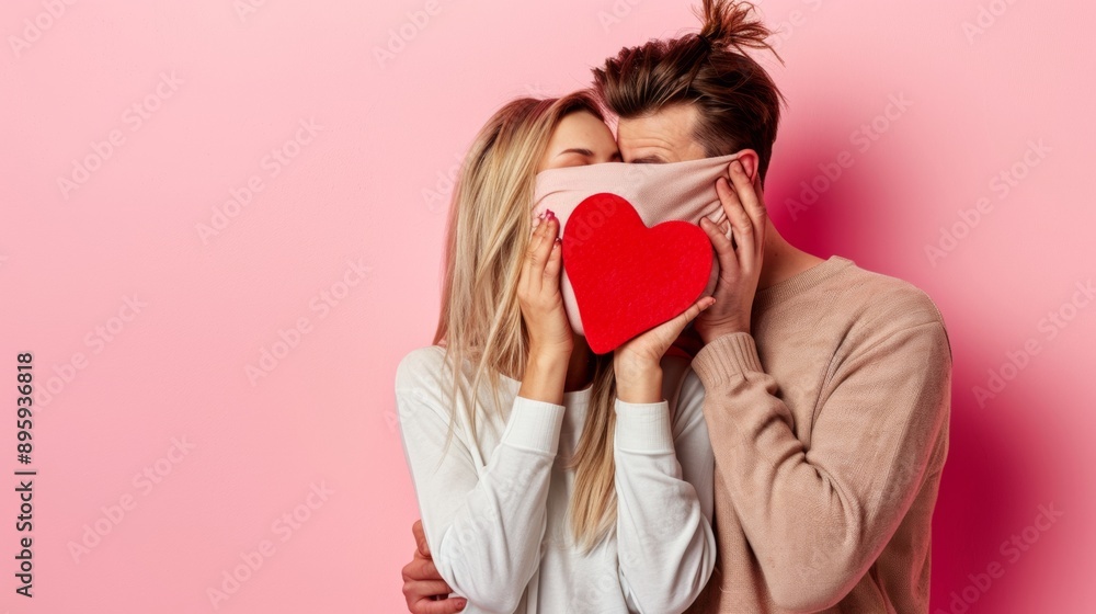 cute couple in love giving each other a kiss covering the kiss with a ...