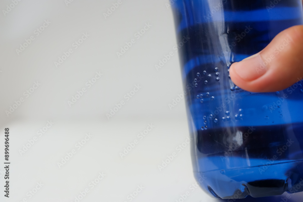 Braille font on a plastic water bottle. Raised dots on the plastic ...