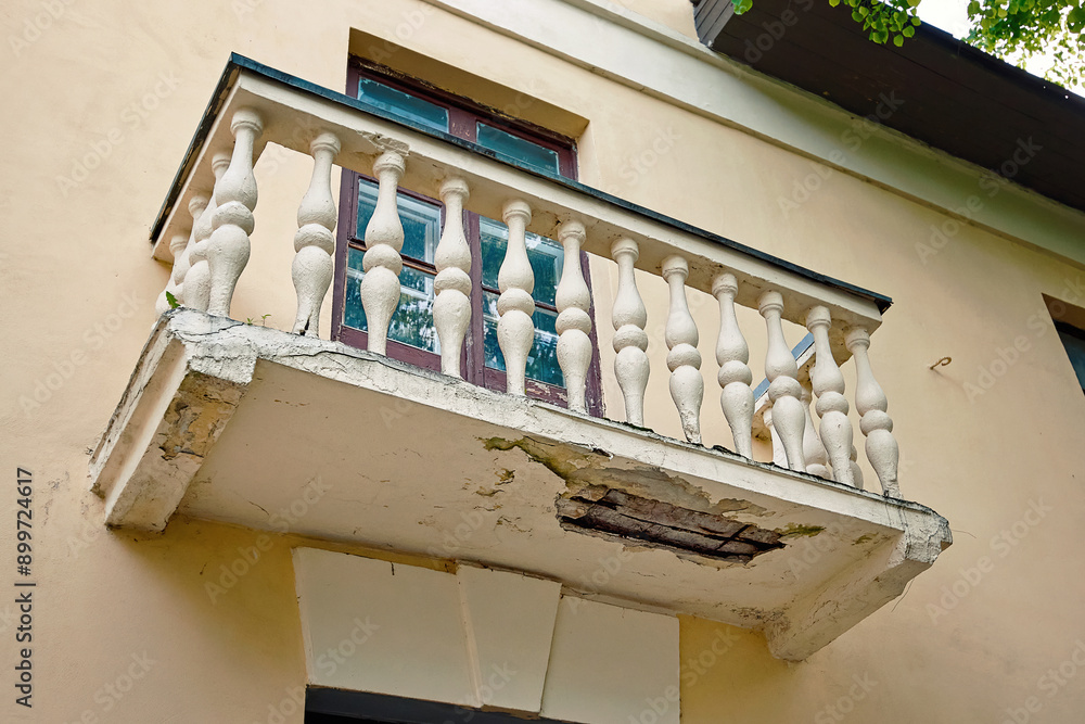 Damaged balcony with cracked concrete and falling plaster, floor need ...
