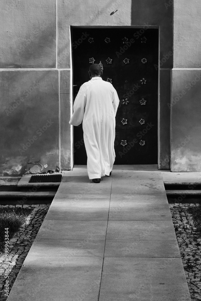 Black and white photograph of a nun in a white habit entering a church ...