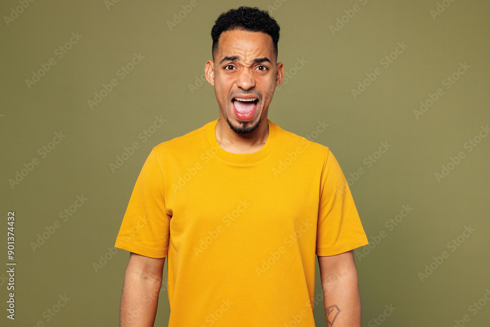 Young mad sad angry man of African American ethnicity wears yellow t ...