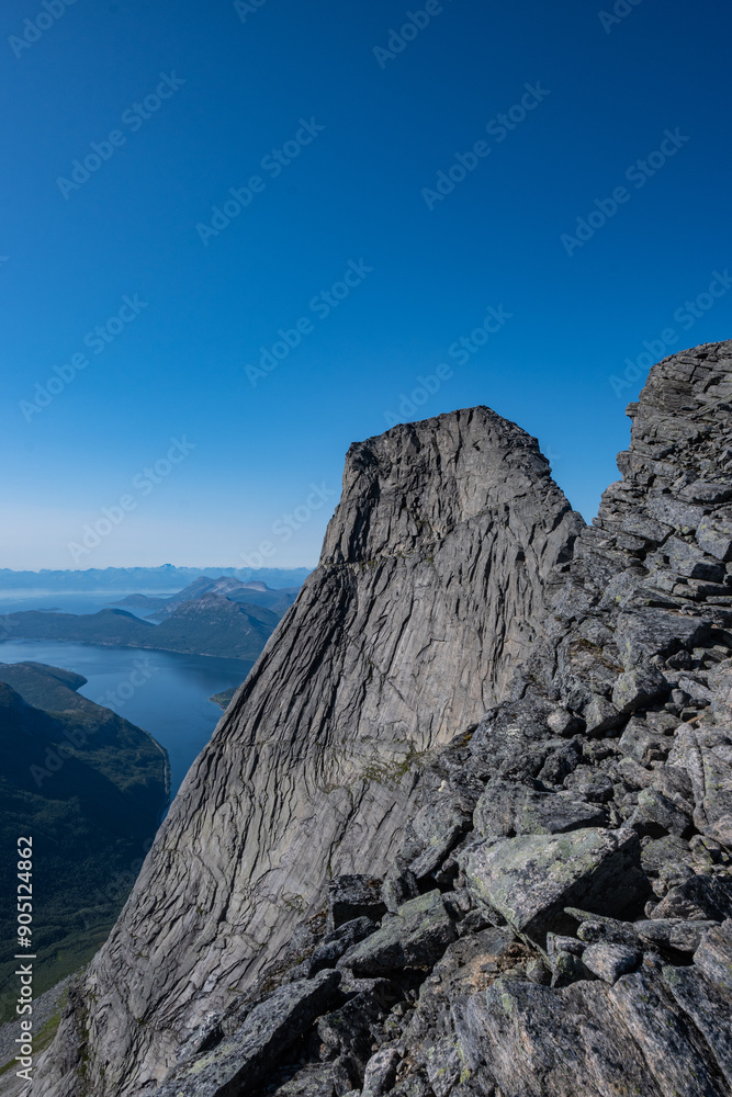 High steep rock walls on the Stetinden peak in North Norway with hikers ...