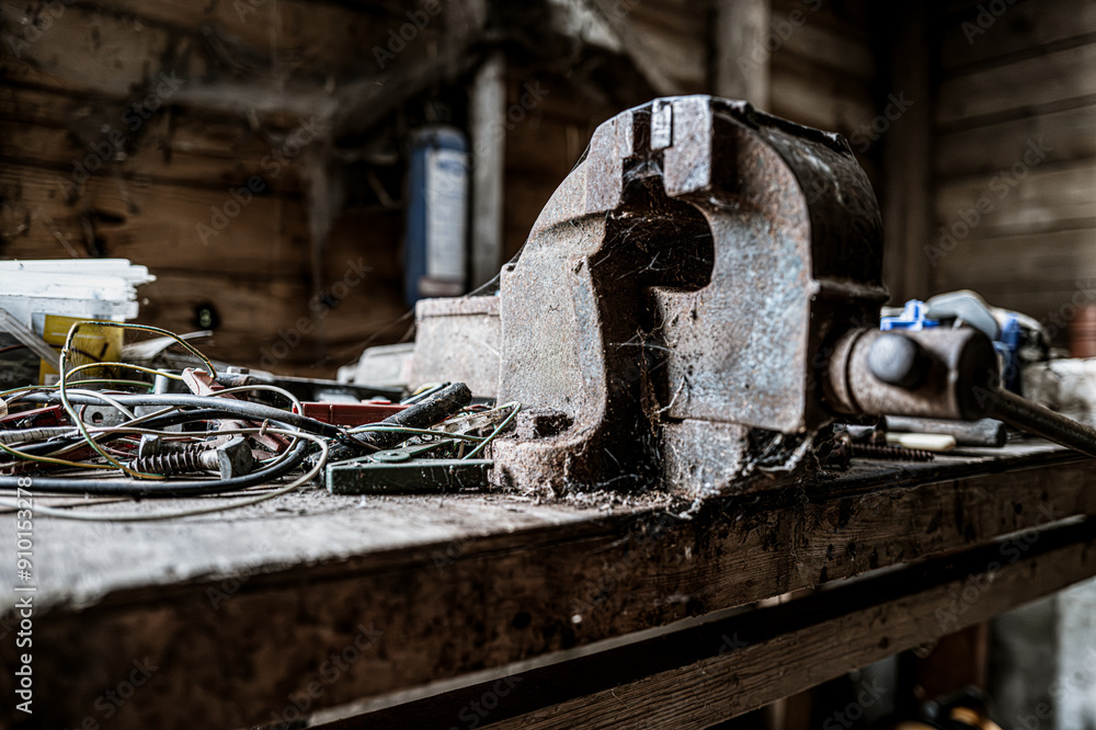 Grunge image of a barn workshop showing a metal vice, various cables ...