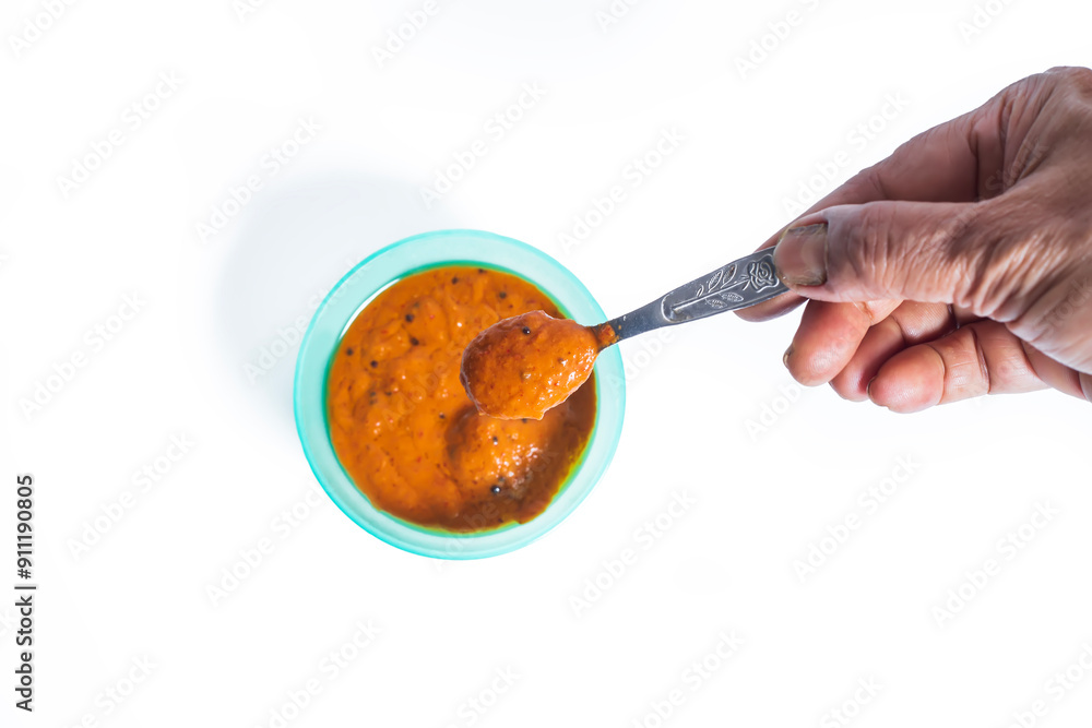 Hand holding spoon with onion chutney on white background with onion ...