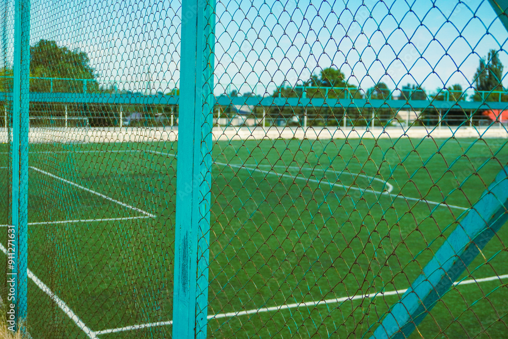 Outdoor Soccer Field behind a mesh fence, with empty bleachers, next to ...