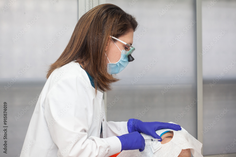 Skin lesion removal procedure. Dermatologist carrying out a removal of ...