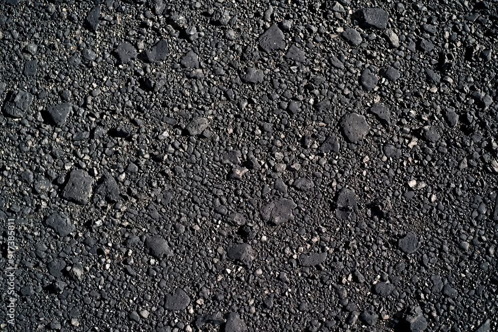 An asphalt texture background showcases a rugged, dark surface with a ...