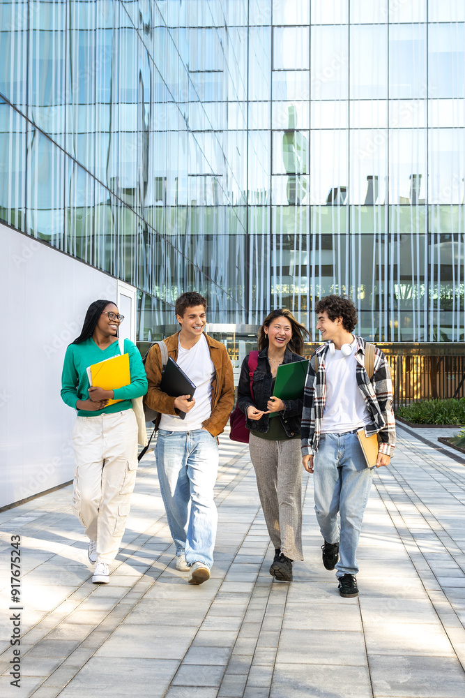 Foto Vertical image of multiracial happy university students walking to ...
