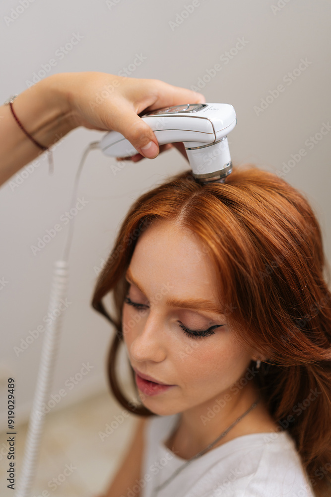 Vertical portrait of pretty female client during treating skin of head ...