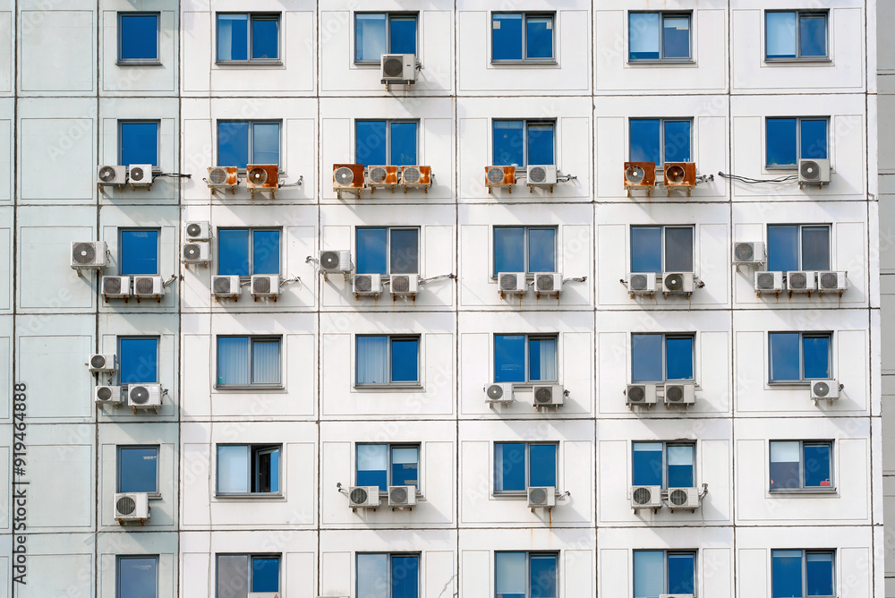 Multiple air conditioning units mounted on the facade of building with ...