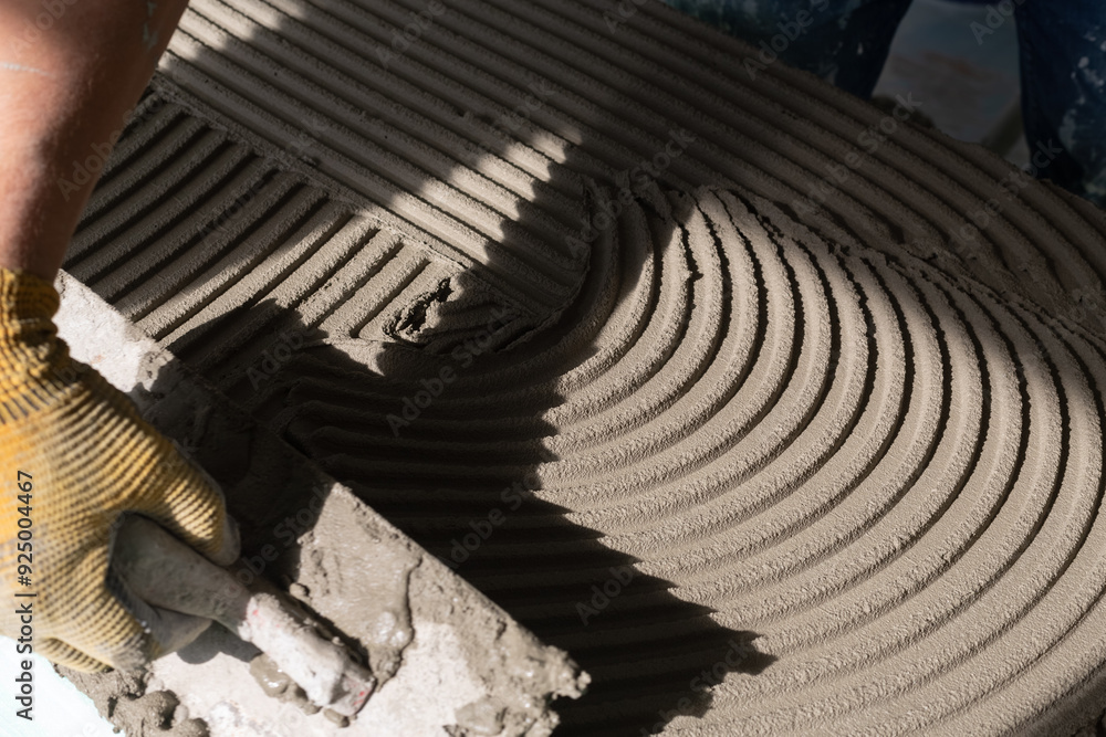 Construction worker bricklayer applies adhesive mortar with trowel on ...