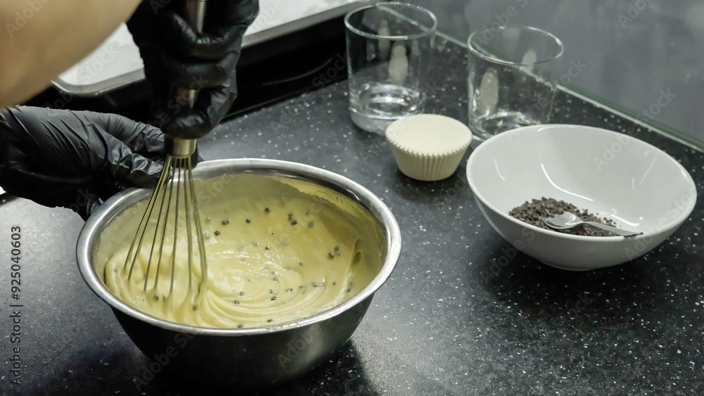 Adding chocolate chunks to the muffin batter and mixing them together ...
