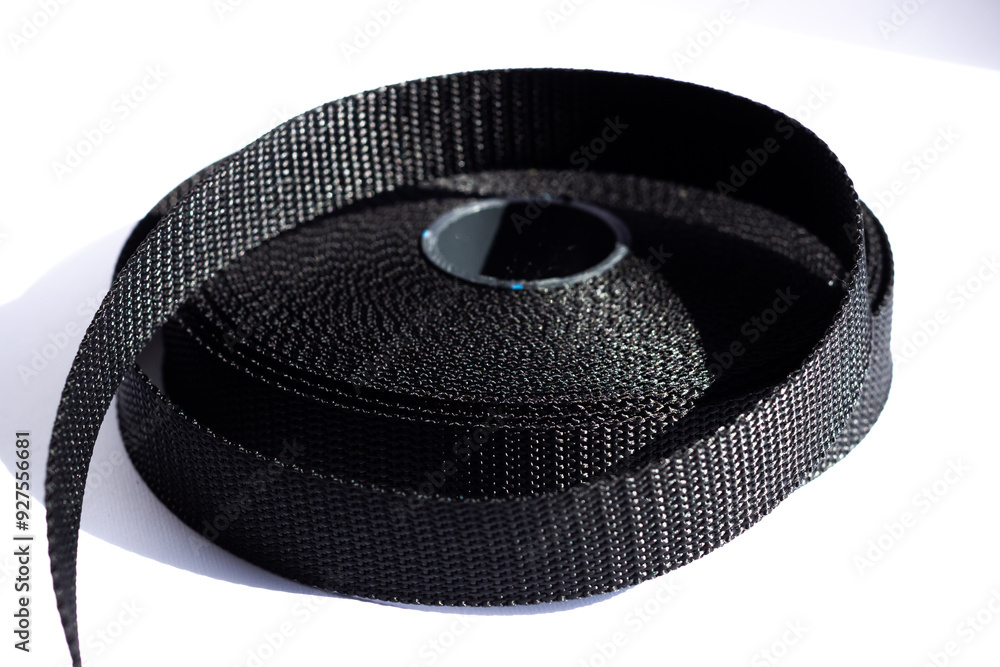 Color horizontal photo, black bobbin of kipper tape, the object is used ...