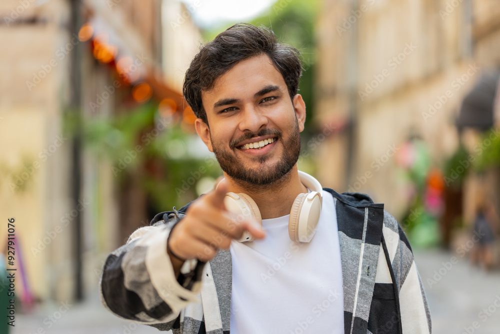 Hey you. Young Indian man tourist smiling excitedly and pointing to ...
