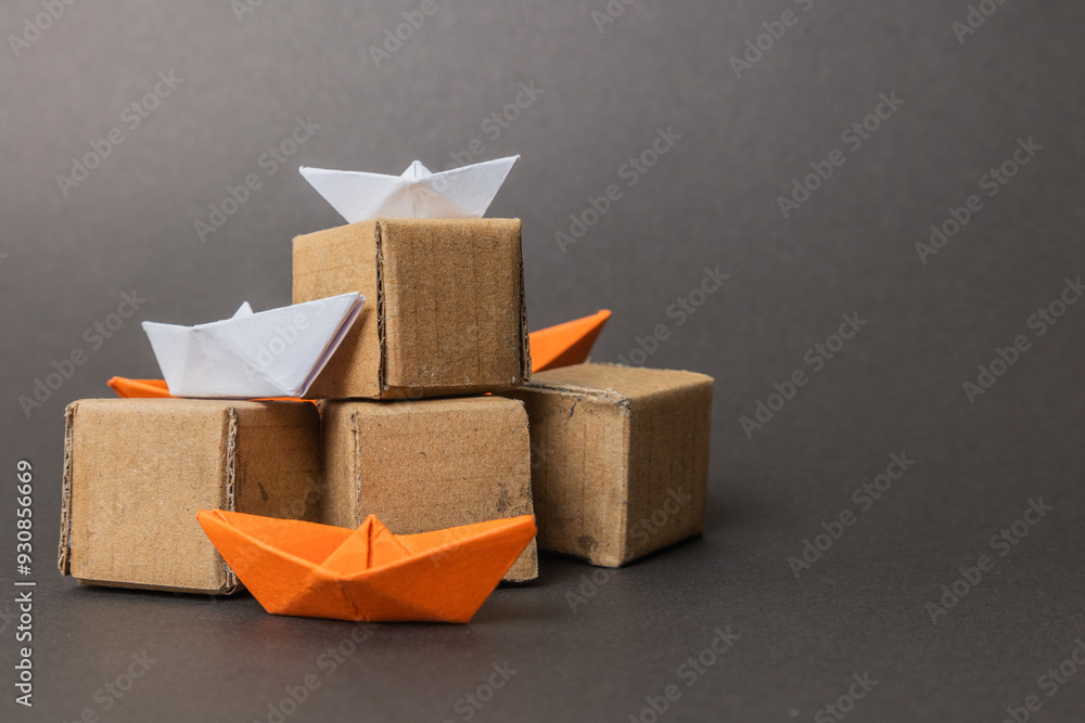 Cardboard boxes stacked with paper boats on top, representing the ...