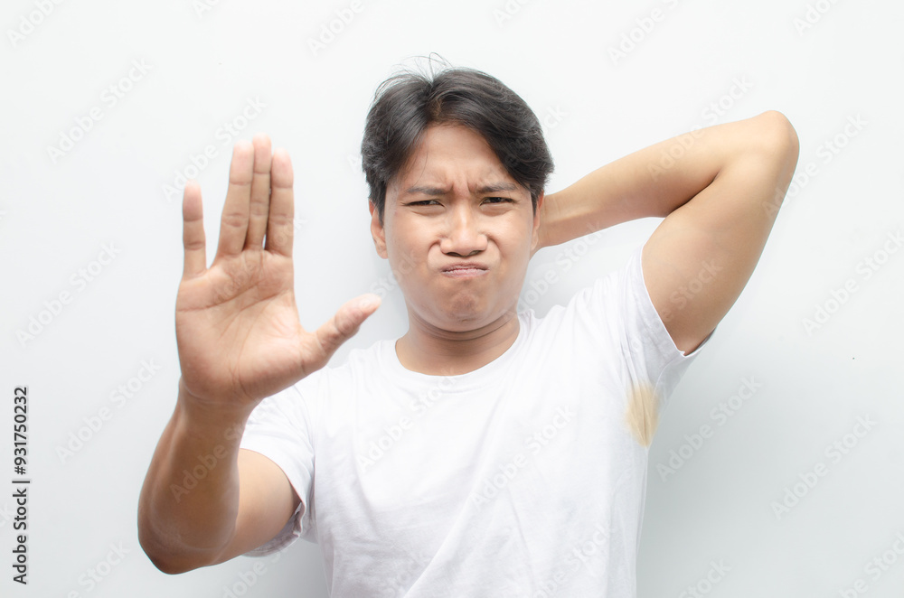 asian man feels bad after smelling his armpit with yellow stain on his ...