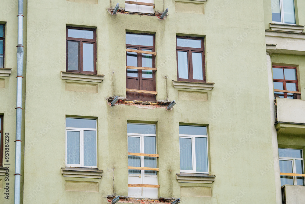 Building facade with dismantled balcony, structural repair, restoration and renovation historic ...