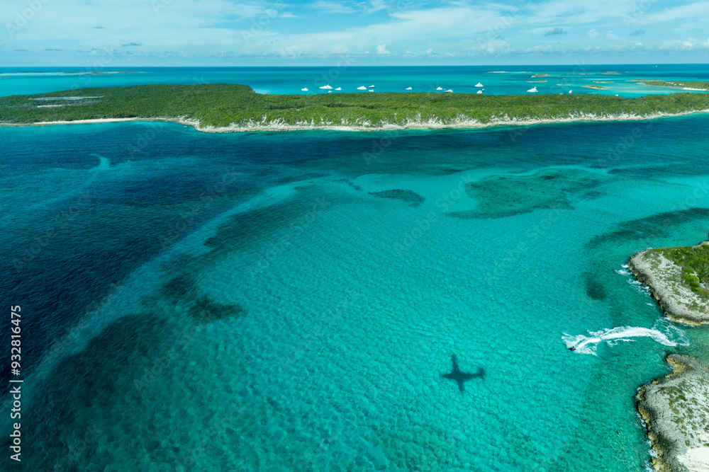 Aerial photo looking down at the airplane's shadow, a jet ski and clear ...