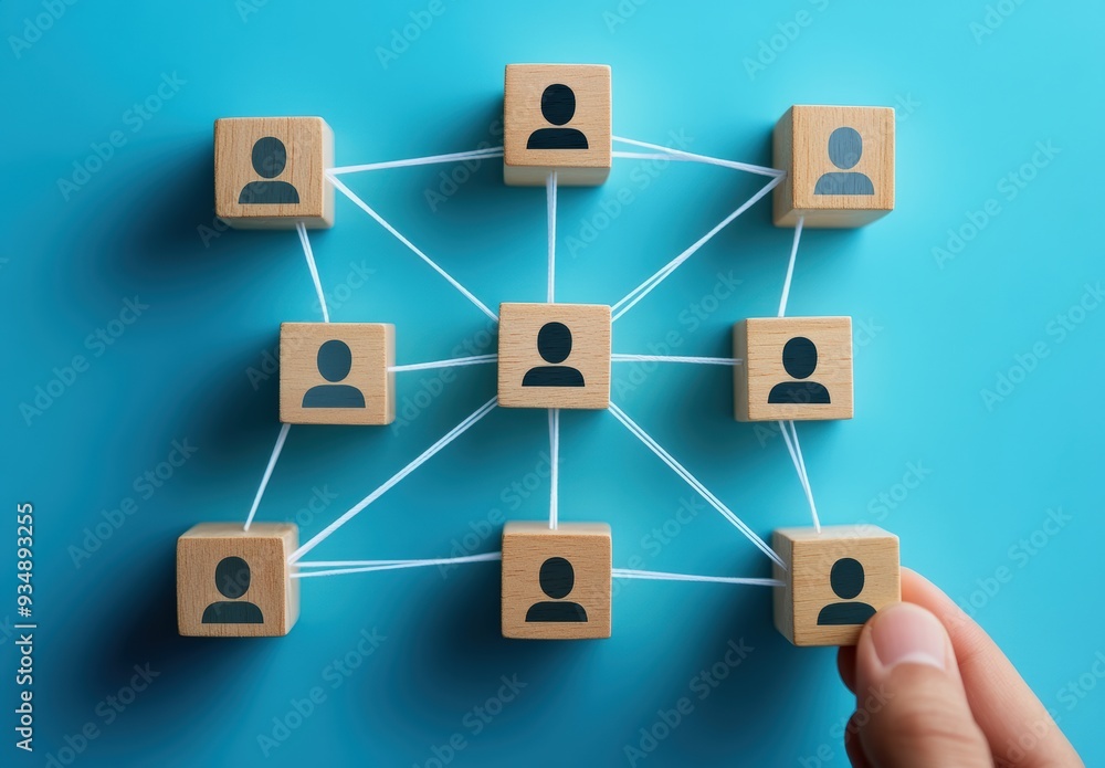 A hand connecting wooden blocks with user icons, illustrating ...