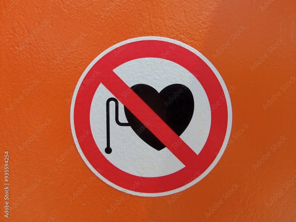 No pacemaker sign on an orange background. The sign is used in ...