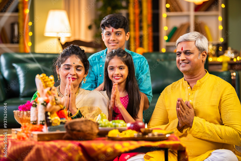 Indian family celebrating Ganesh Chaturthi, performing puja with ...