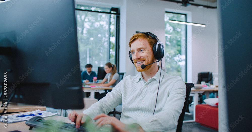View from behind of two large monitors of Caucasian male sitting at ...