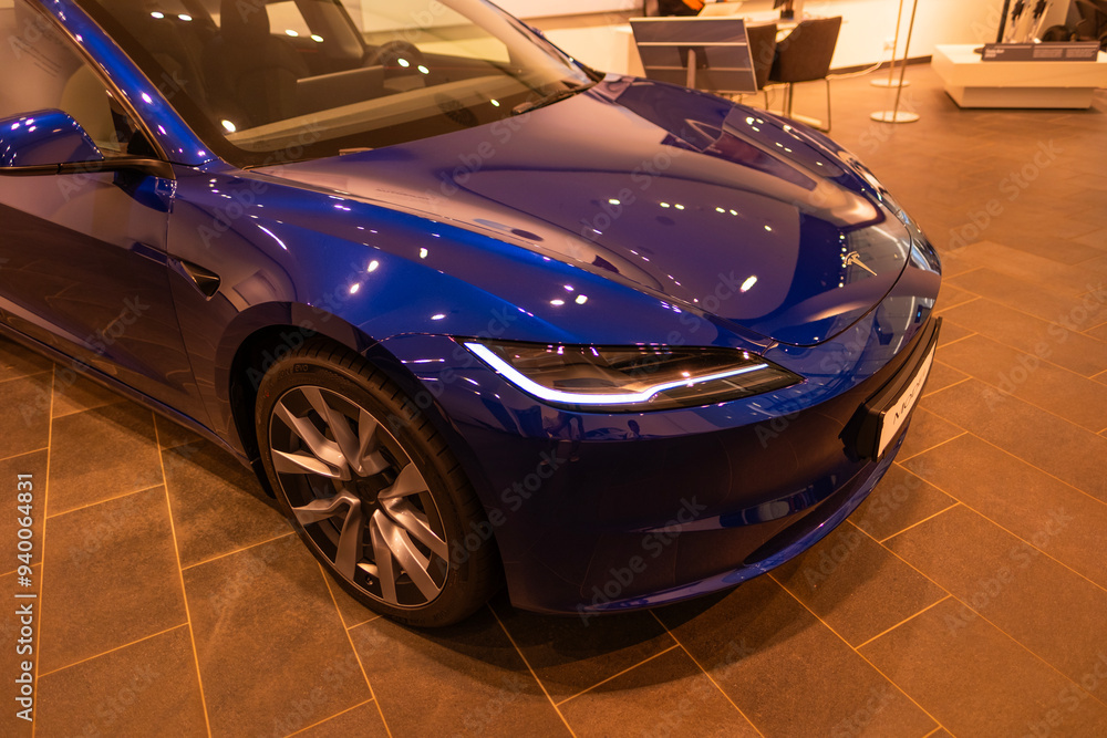 sleek electric blue Tesla Model 3 gleams under showroom lights ...