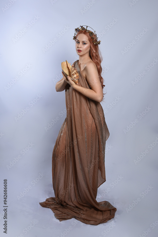 Full length portrait of beautiful female model wearing silken toga ...