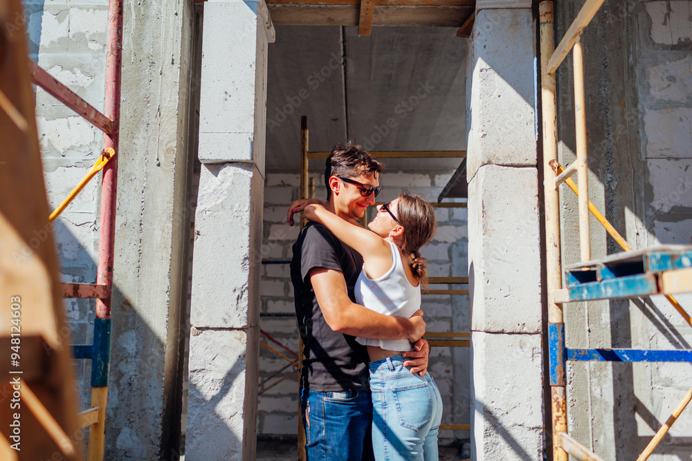 Young married couple checking their future house under construction ...