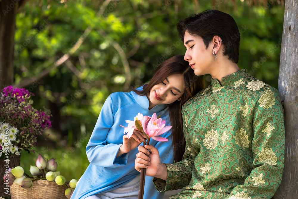 Portrait man and woman in Vietnamese costumes holding lotus flower ...