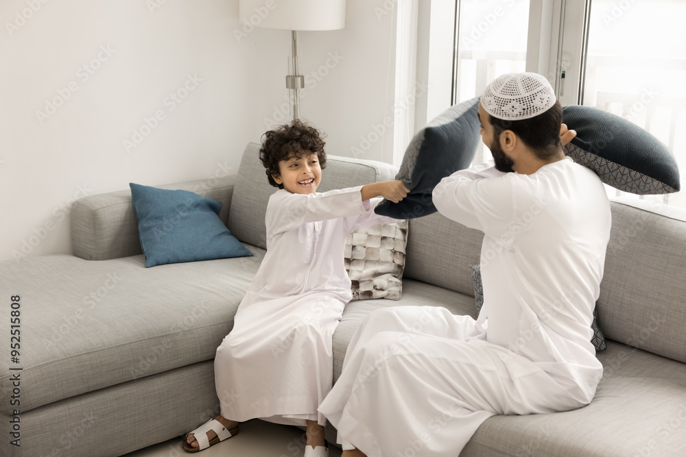 Cheerful Arabic dad and excited son kid in Muslim thobes enjoying ...
