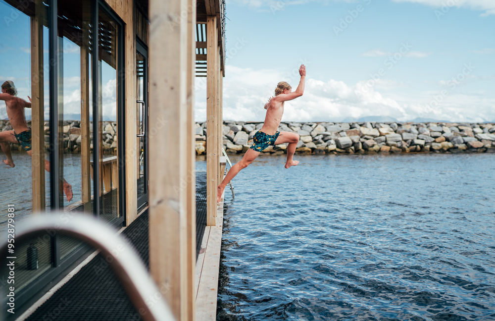 Jumping teen boy into the cold Fjord water from Scandinavian floating ...