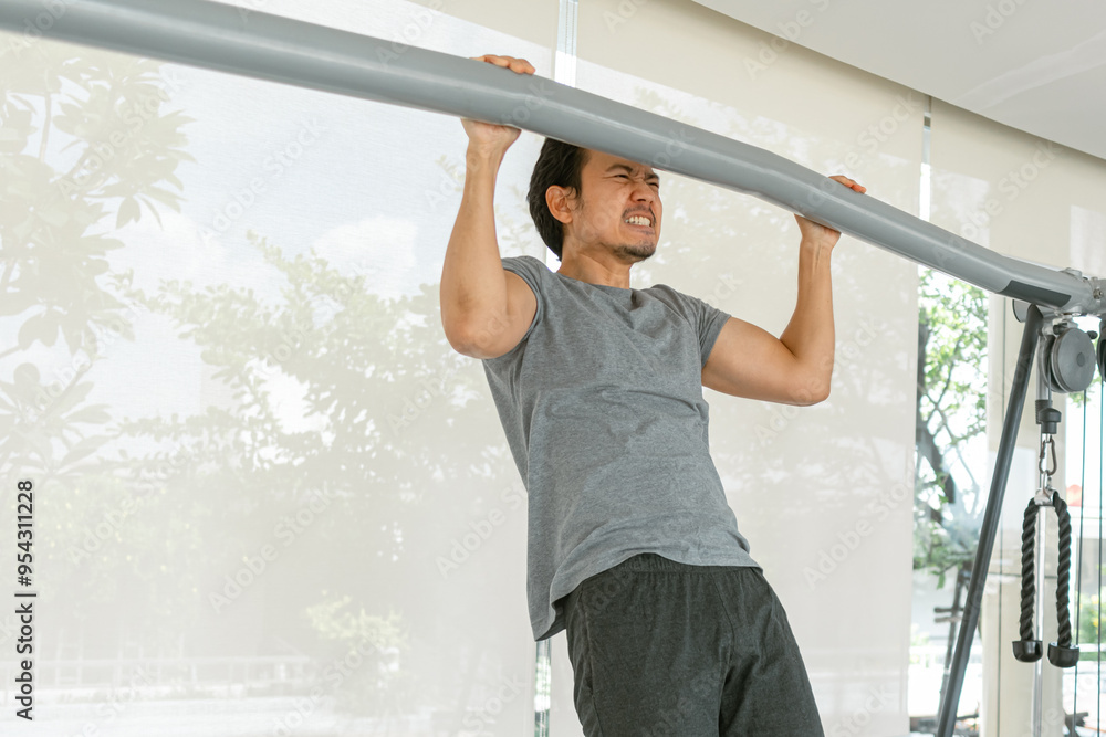 Asian fitness man hanging and pull-up bars at gym, gaining and building ...