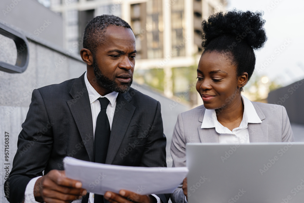 Smiling secretary entering data from documents into laptop Stock Photo ...