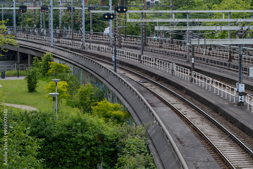 Curved railway tracks lead through an industrial environment ...